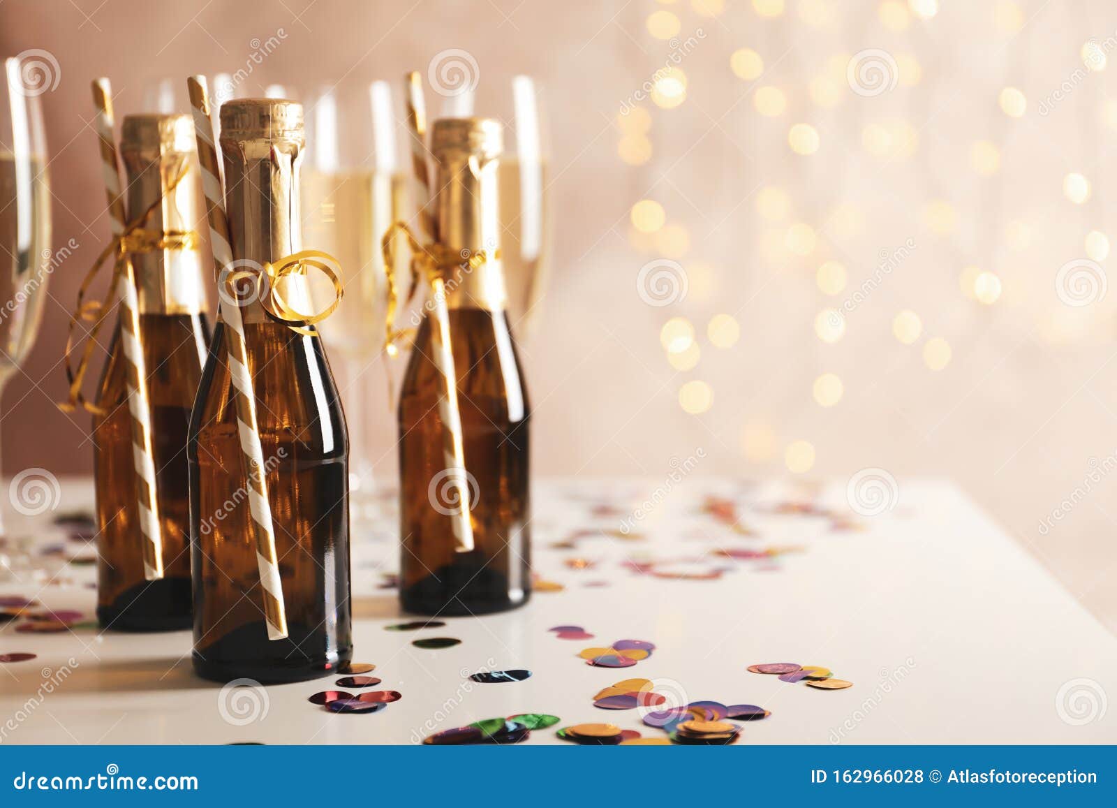 Champagne Glasses and Mini Bottles on Decorated Background Stock Photo ...
