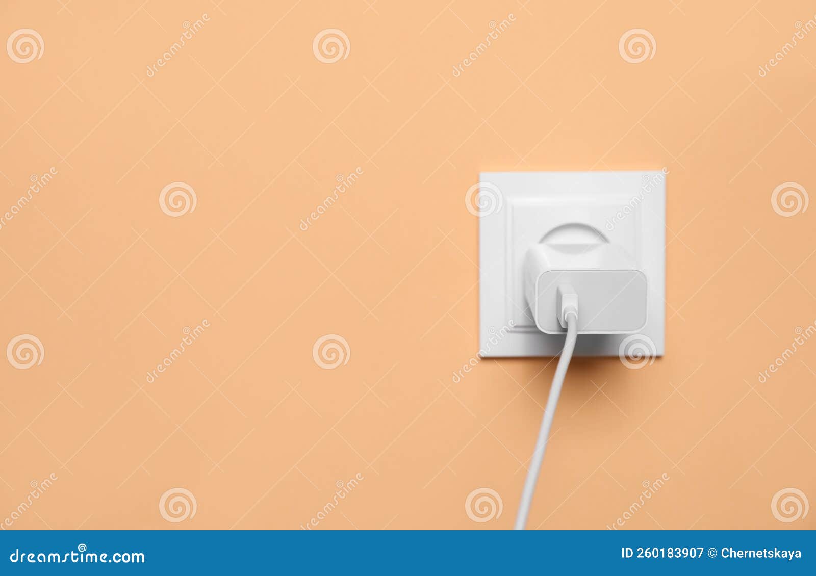 Charger Adapter Plugged into Power Socket on Pale Orange Wall, Space ...