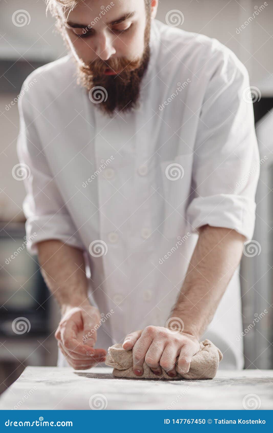 Charismatic Baker with a Beard and Mustache Kneads Dough on the Table ...