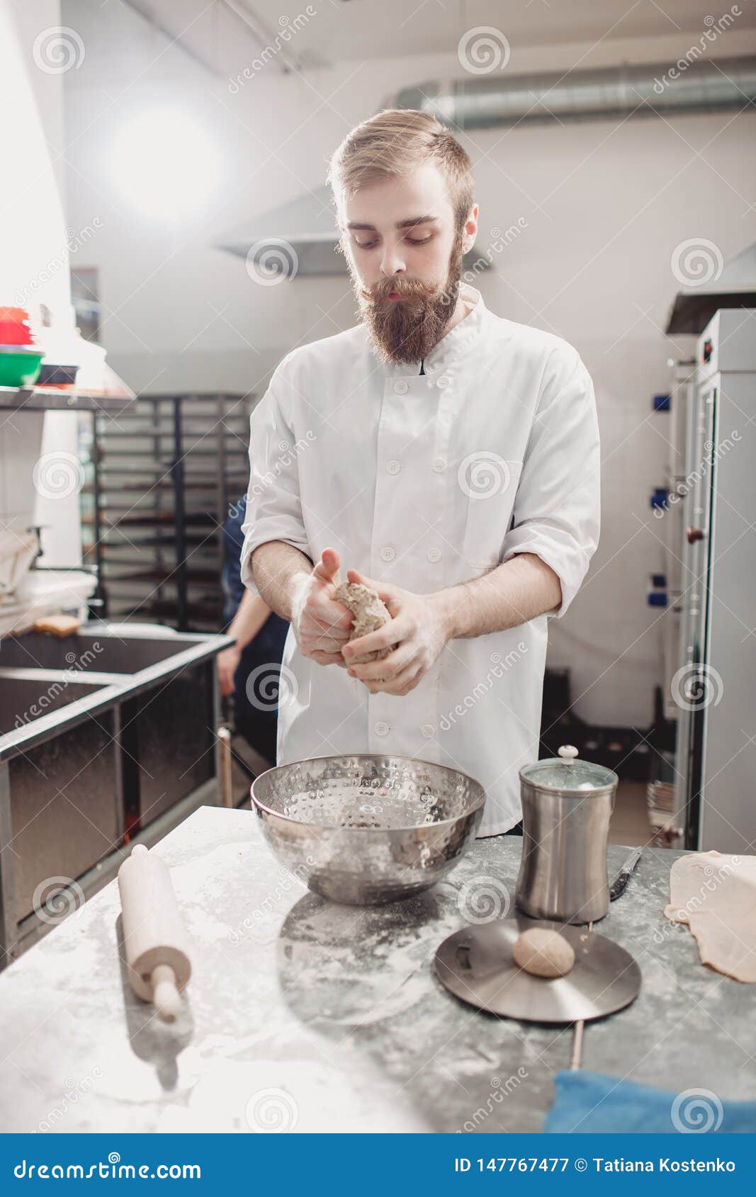 Charismatic Baker with a Beard and Mustache Kneads Dough on the Table ...