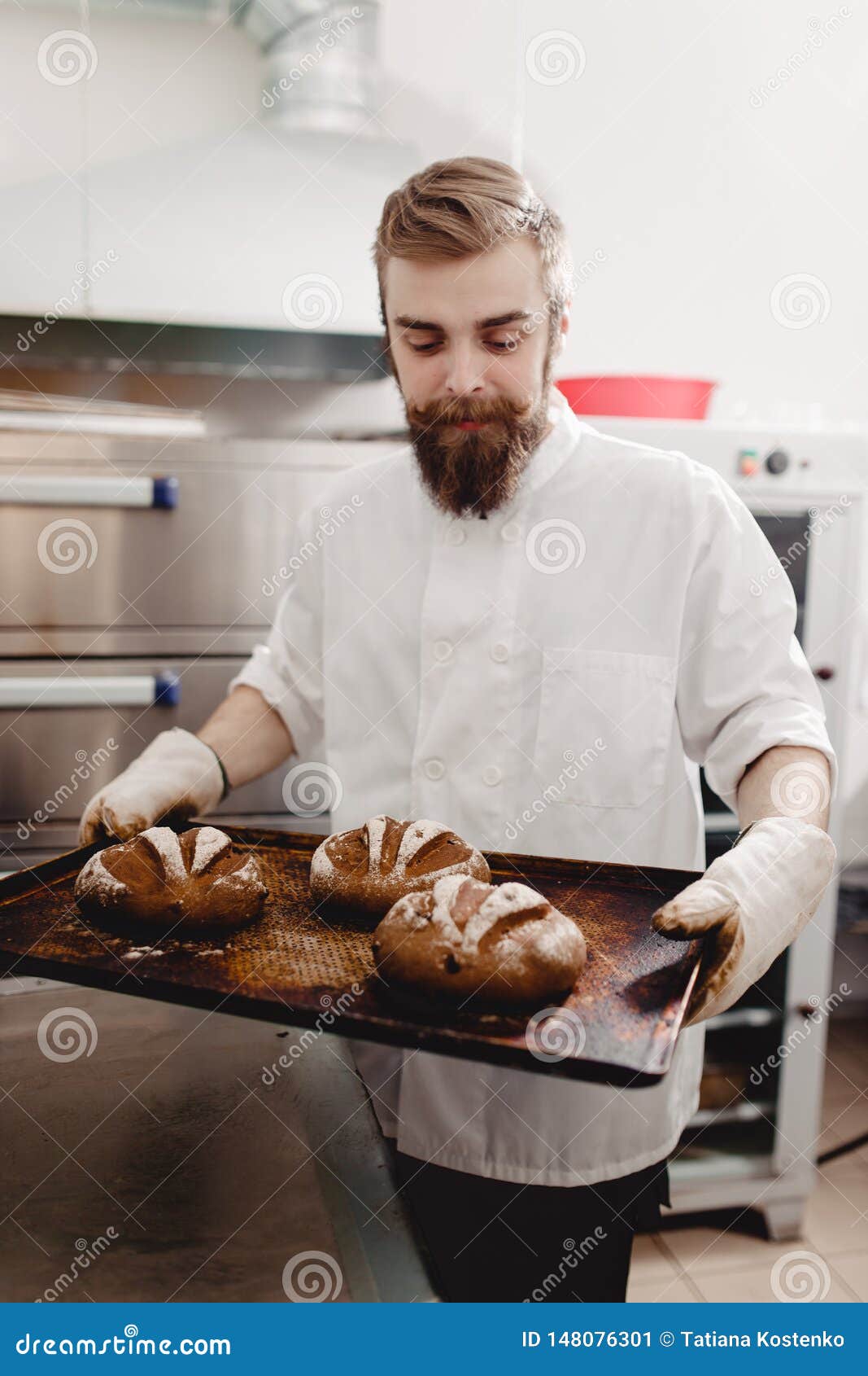 Charismatic Baker Holds the Baking Tray with Newly-baked Bread in the ...