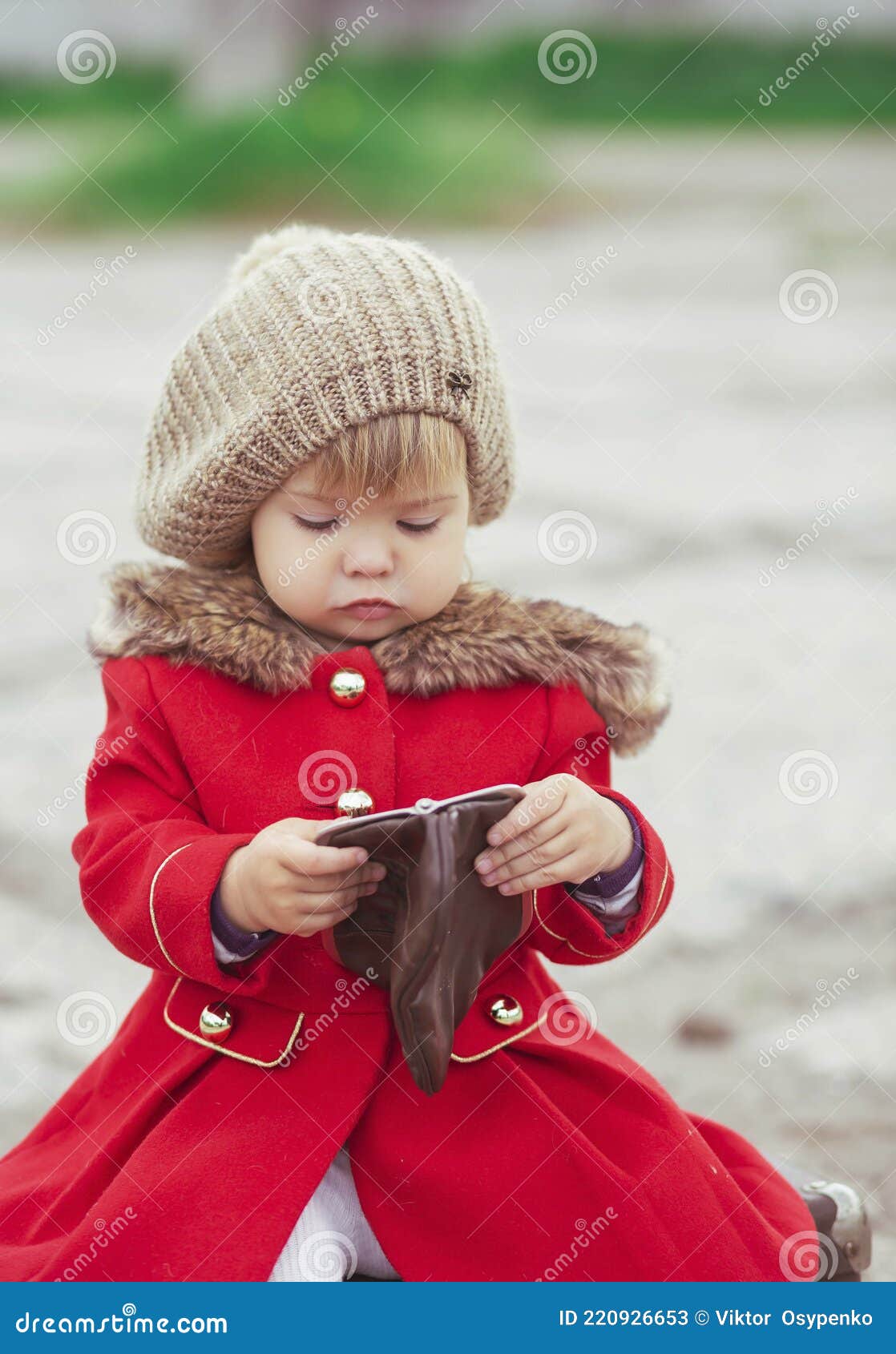 Charming Baby in a Red Coat Looks into Wallet Stock Image - Image of ...