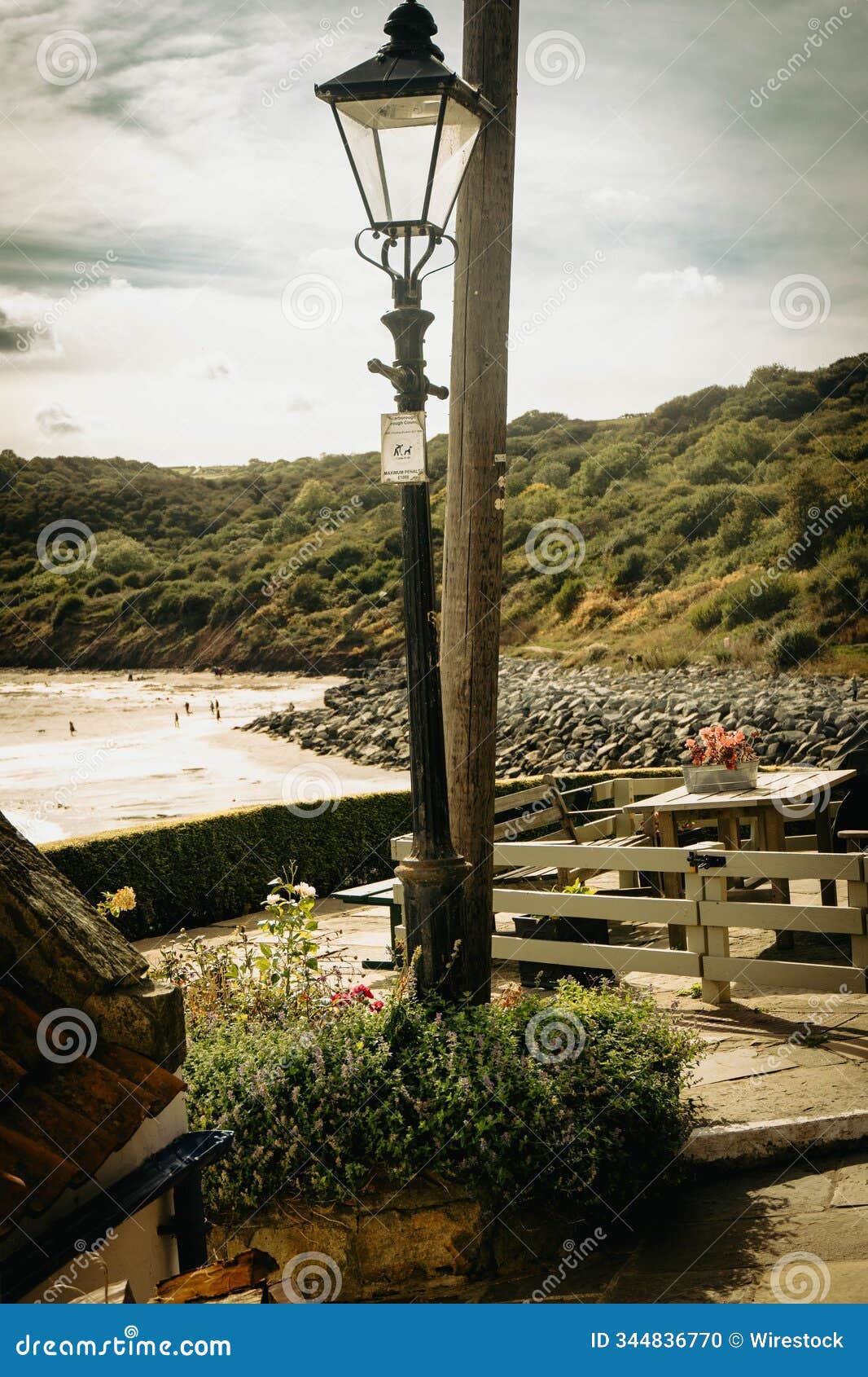 Charming Coastal Scene with a Vintage Lamp Post Overlooking a Sandy ...