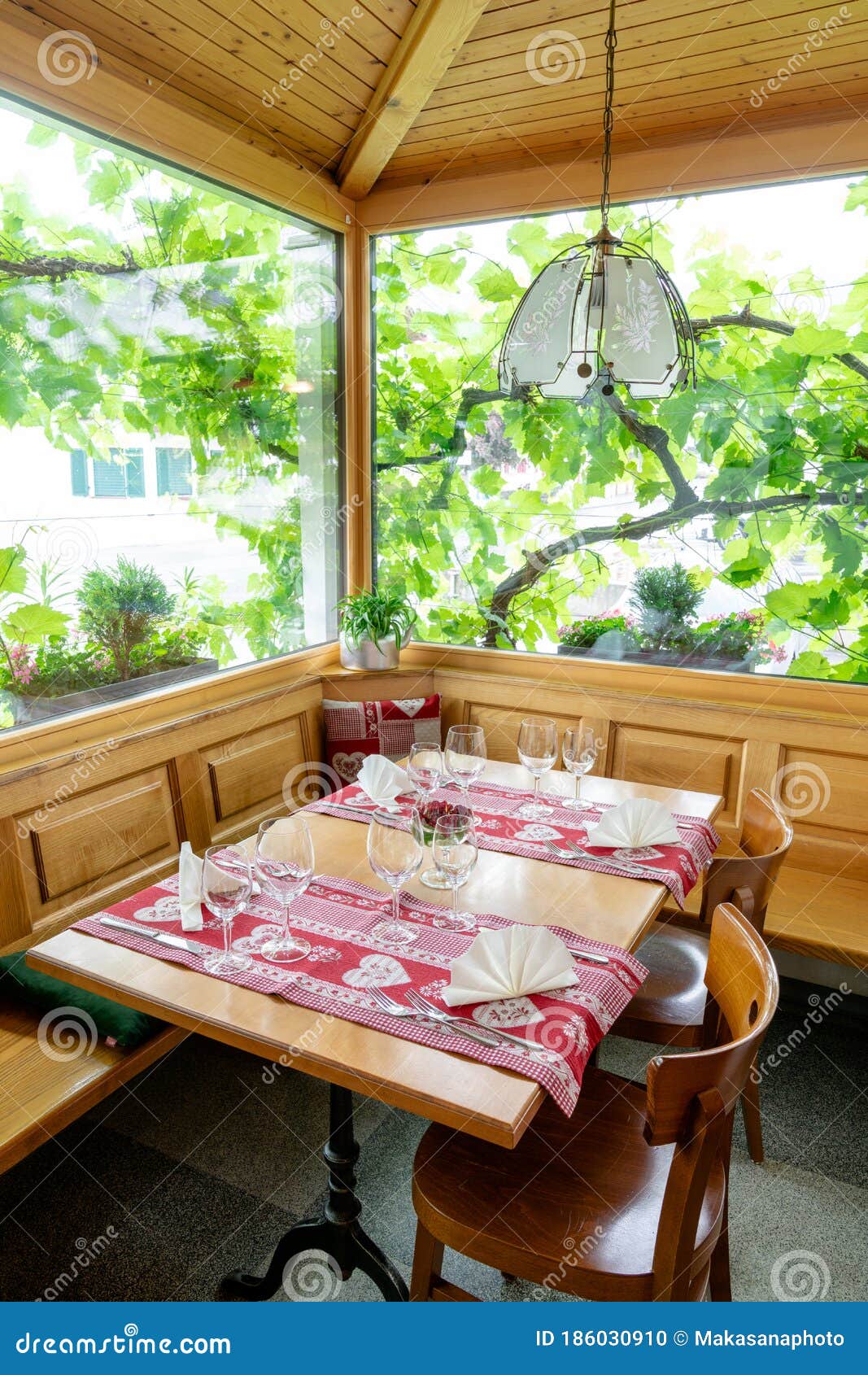 Charming and Inviting Restaurant Table with a Bay Window and Grapevines ...