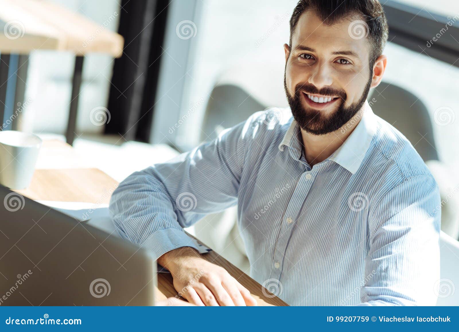 Charming Young Man Smiling at Camera while Working in Office Stock ...