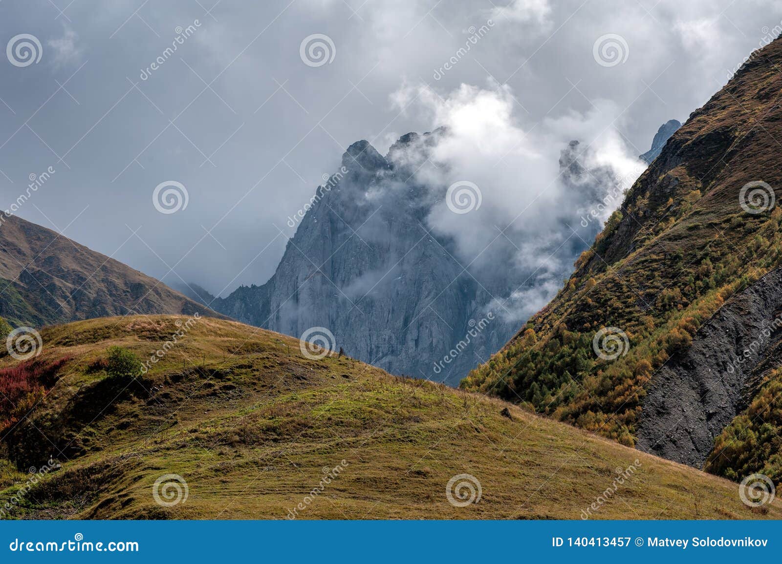 The Chaukhi Massif between Green Grass Covered Slopes Stock Image ...