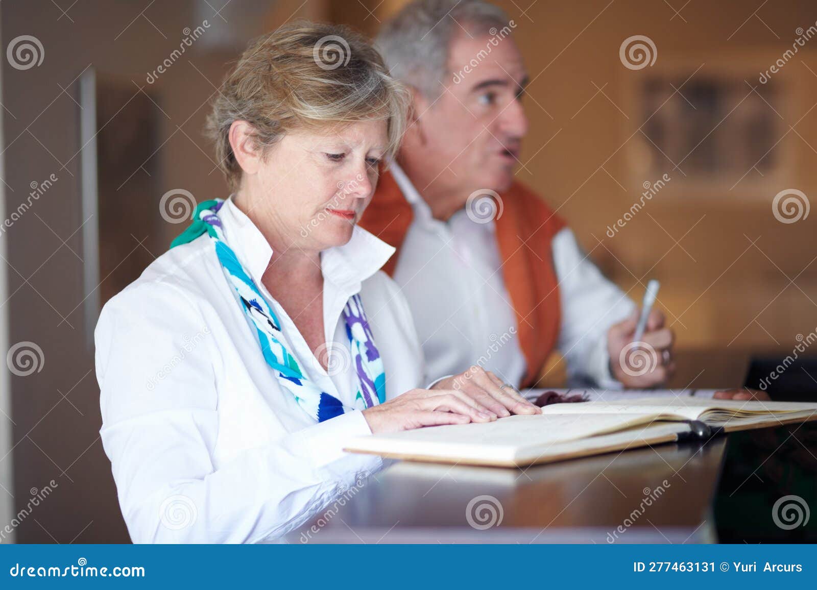 At the Check in Counter. a Senior Couple Checking in at the Hotel ...