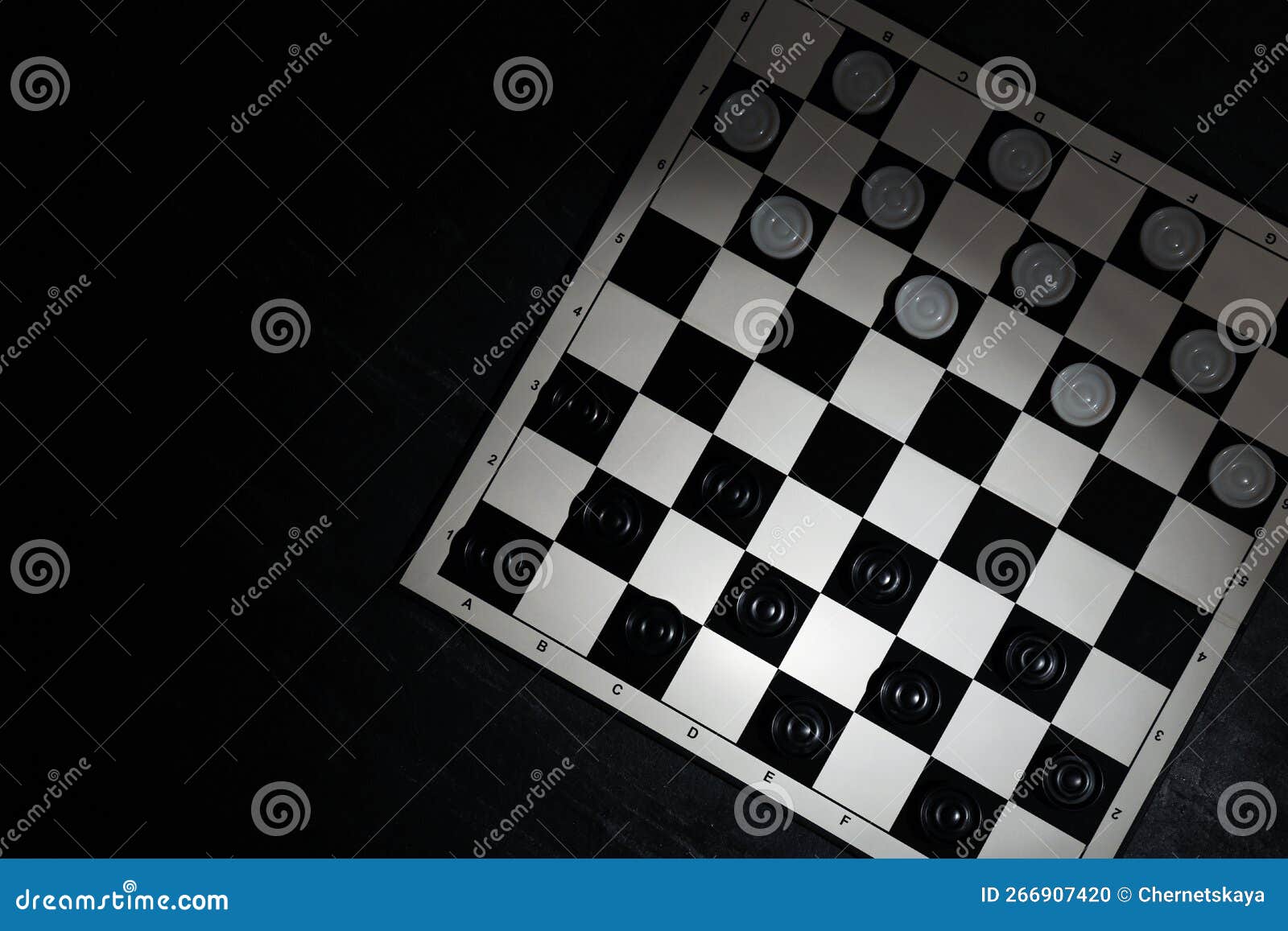 Checkerboard with Game Pieces on Black Table, Top View. Space for Text ...