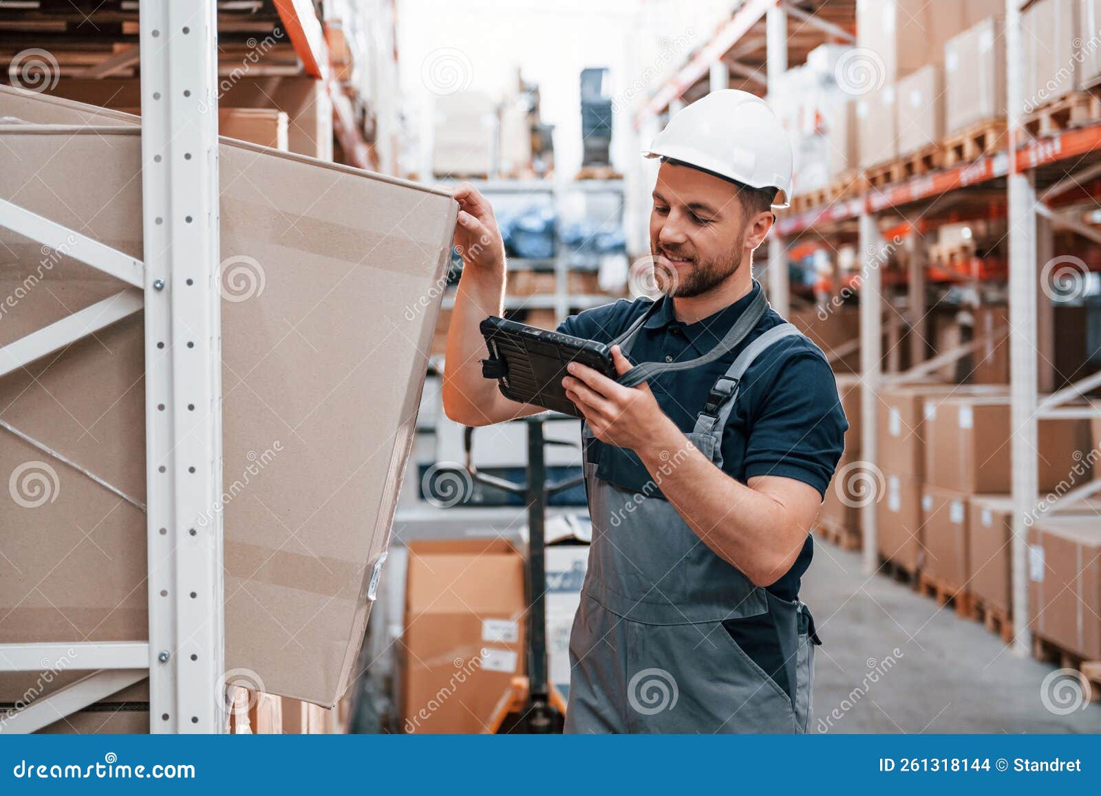 Checking the Box. Employee in Uniform is Working in the Storage at ...