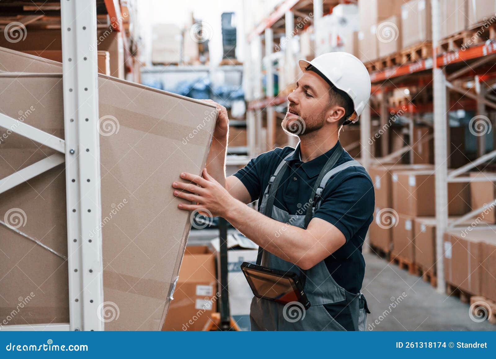 Checking the Box. Employee in Uniform is Working in the Storage at ...