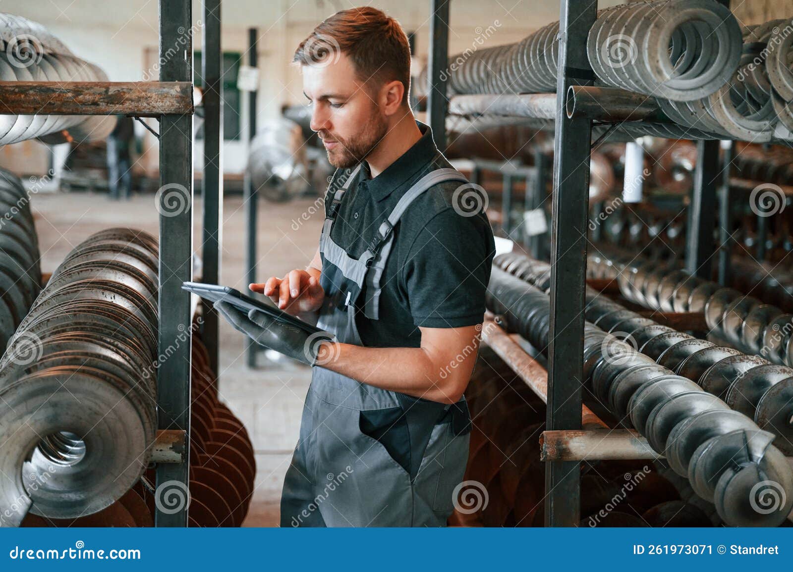 Checking Details. Man in Uniform is in Workstation Developing Details ...