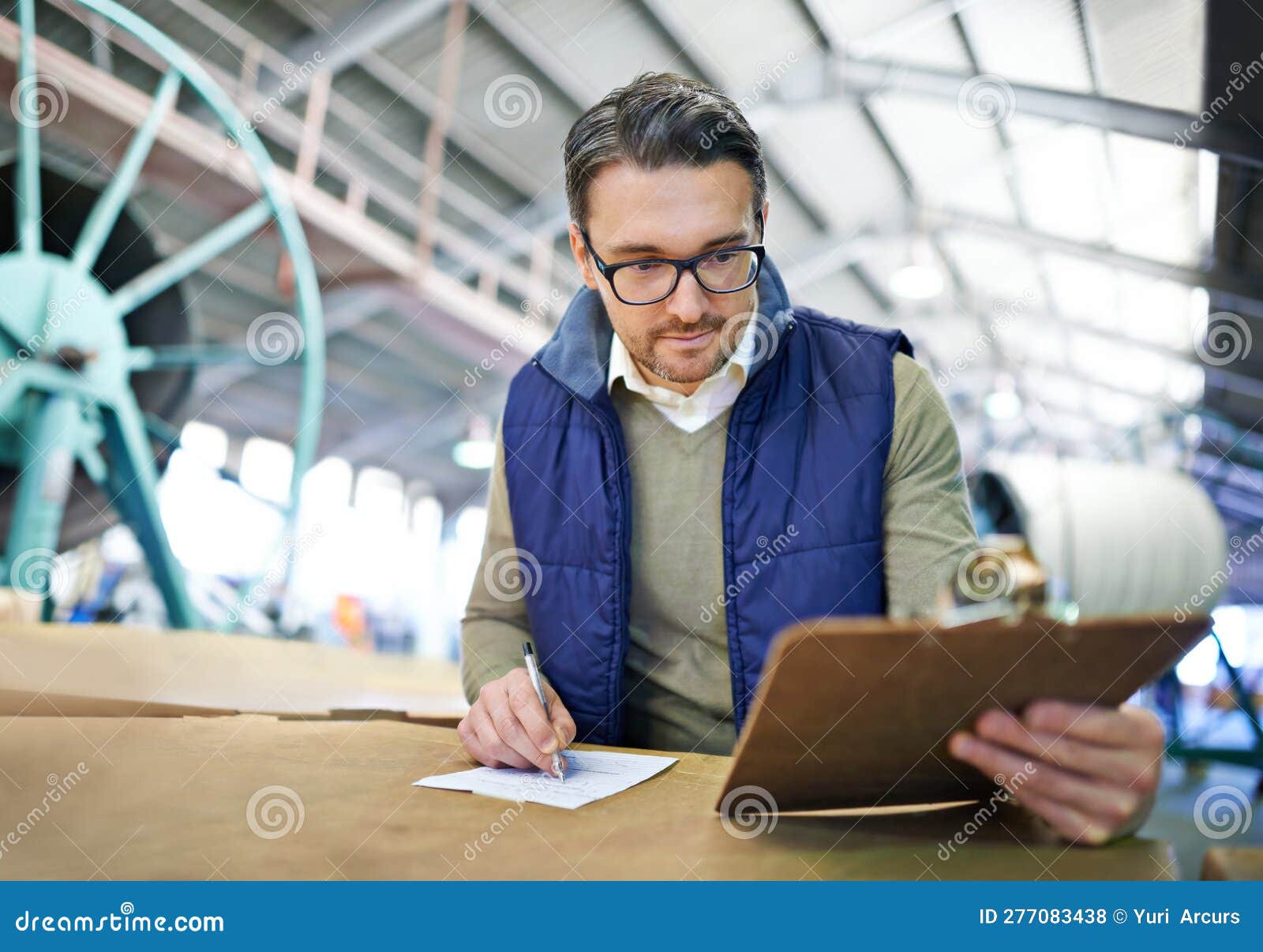 Checking and Double-checking Orders. a Man Reading Paperwork in a Large ...
