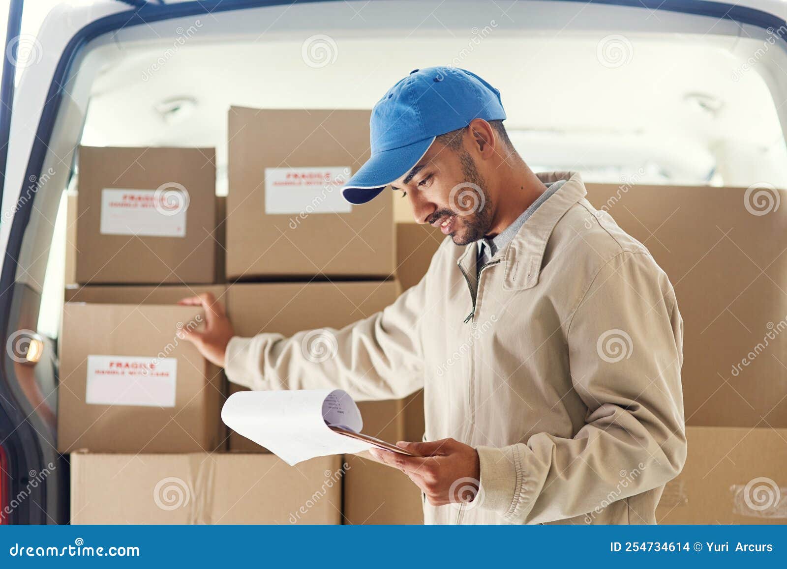 Checking His Orders. a Handsome Young Delivery Man Checking His Orders ...