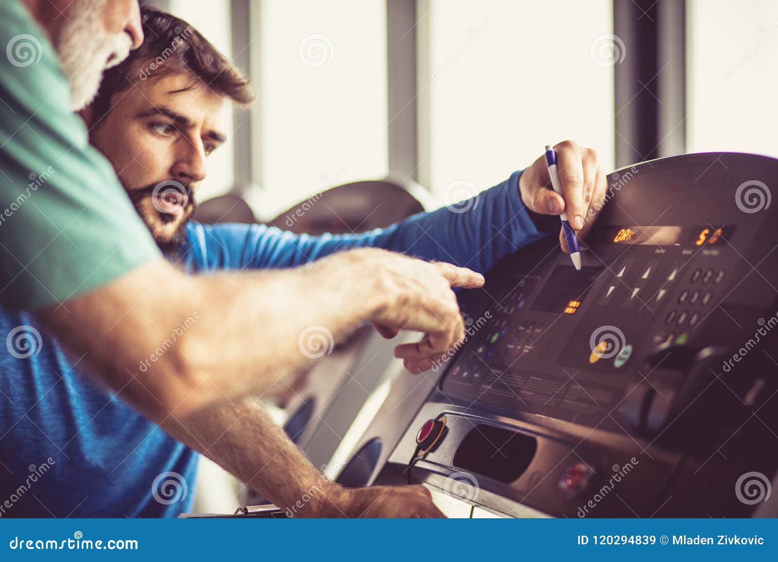 Checking Speed on Exercise Machine. Stock Image - Image of conversation ...