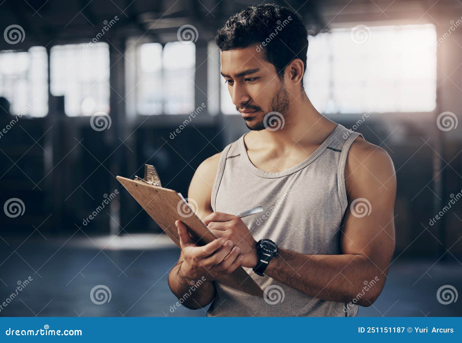 Checking Up on His Training Inventory. a Muscular Young Man Writing ...