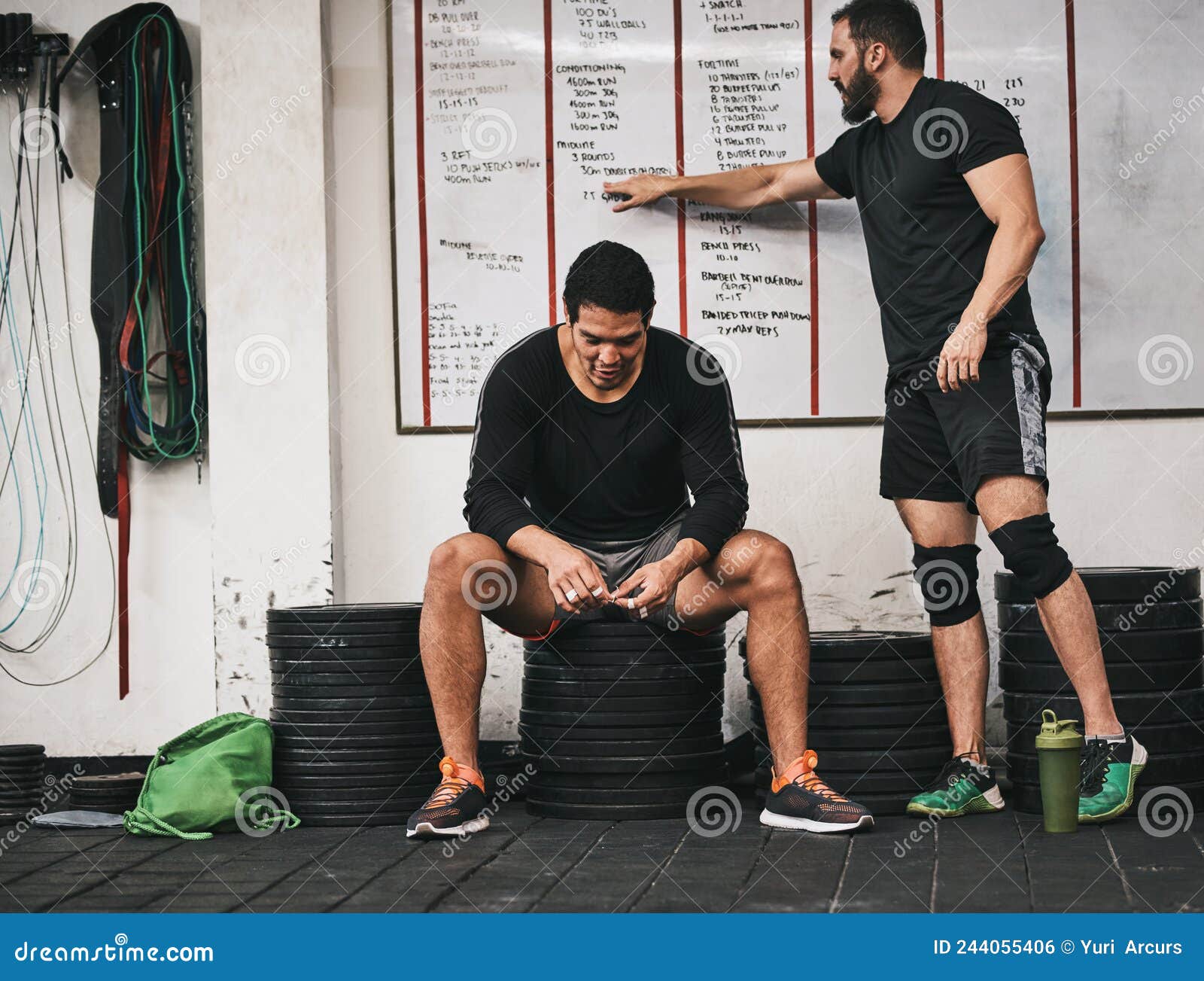 Checking the Workout Agenda. Shot of People Taking a Break in a Gym ...