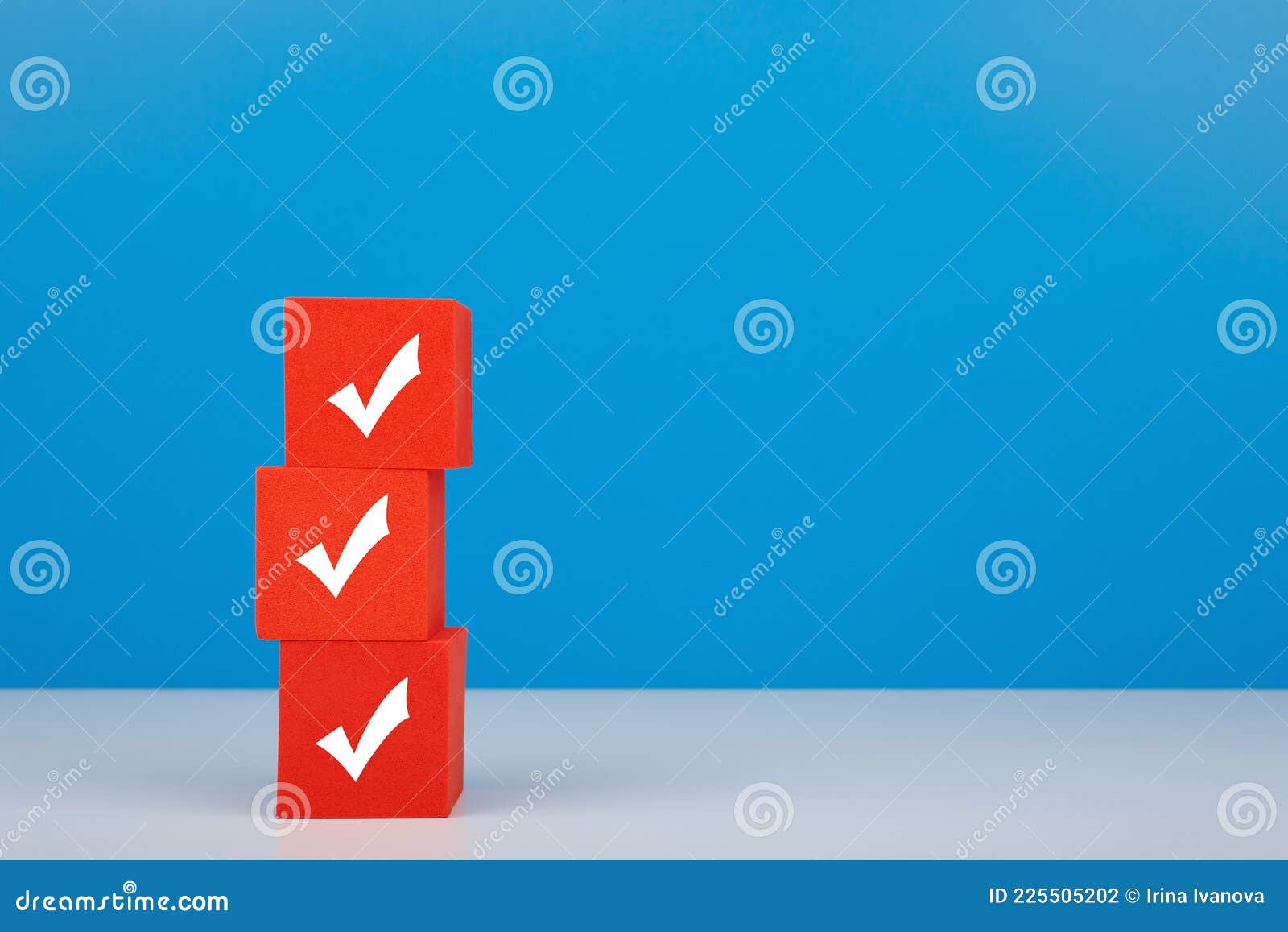 Checkmarks on Three Red Blocks on White Table Against Blue Background ...