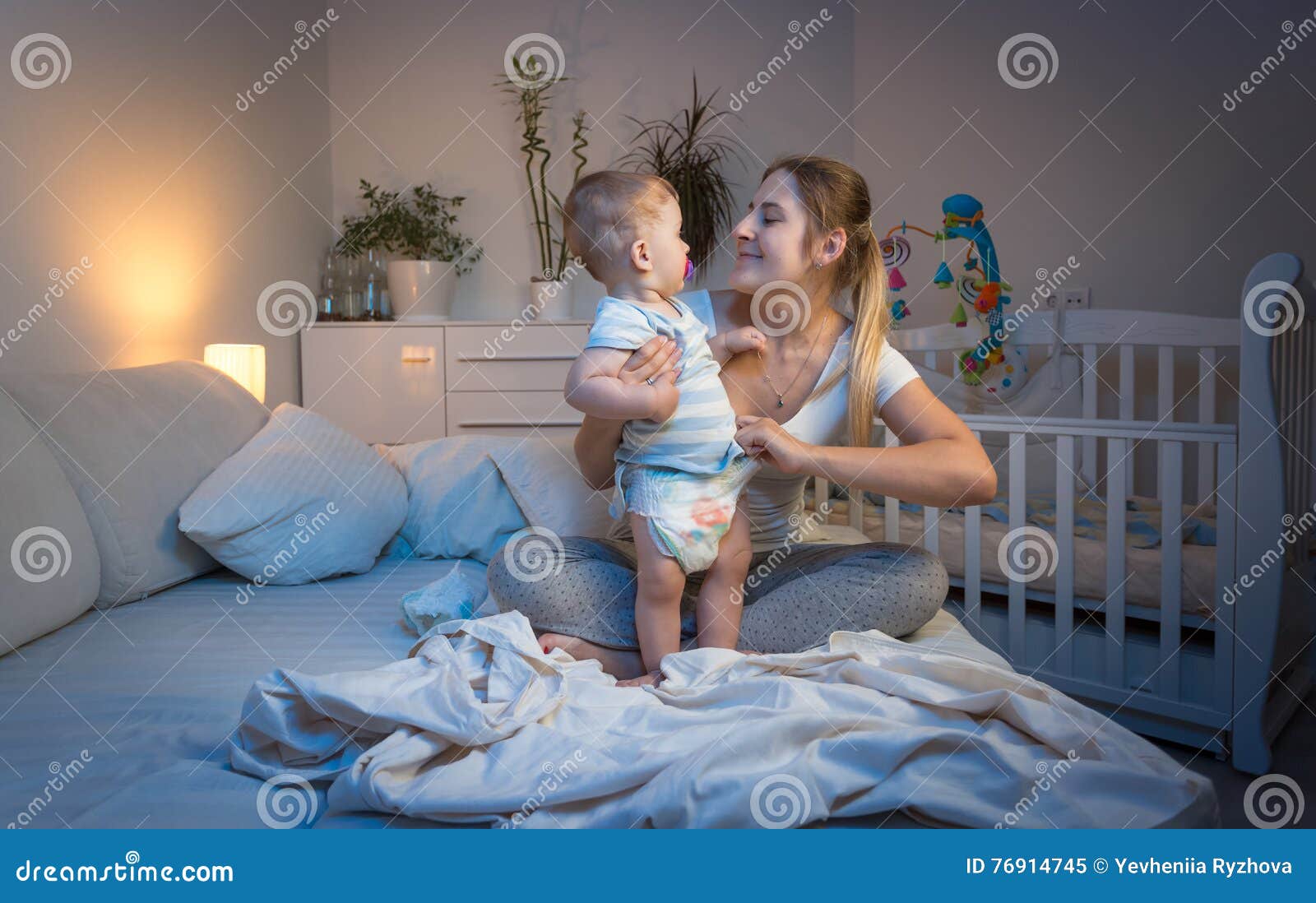 Cheerful Baby Boy Playing with Mother on Bed at Night Stock Image ... Cheerful Baby Boy Playing with Mother on Bed at Night Stock Image ...