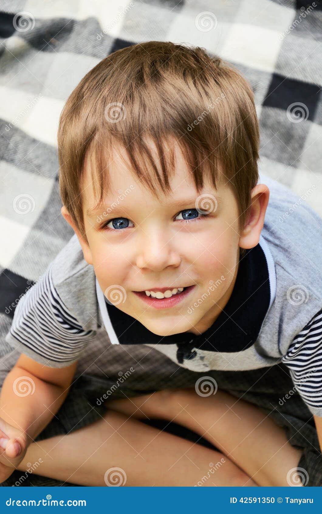 Cheerful Boy Sitting on Carpet and Looking from the Bottom Up Stock ...