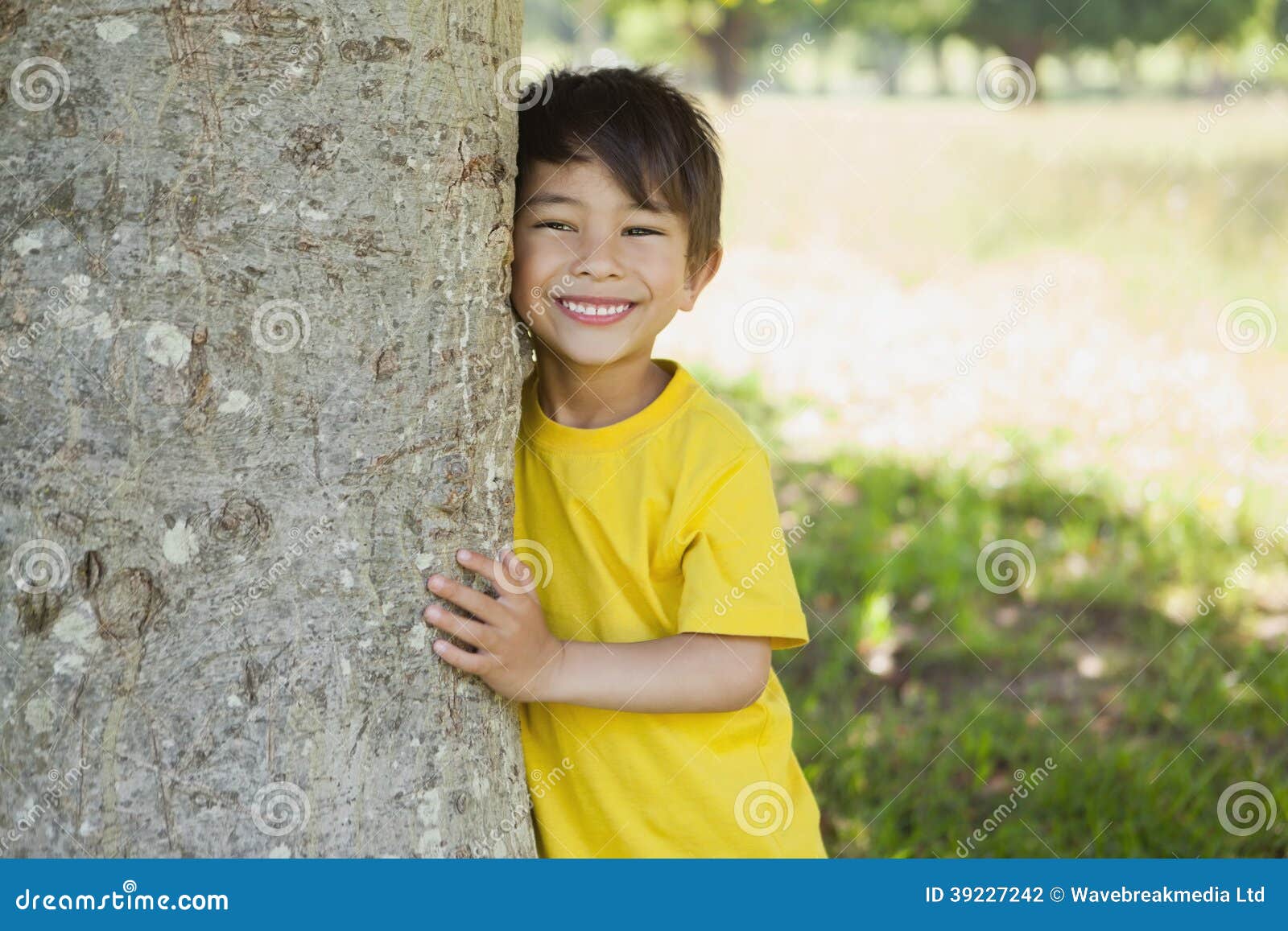 Cheerful Boy Standing by Tree at Park Stock Photo - Image of looking ...