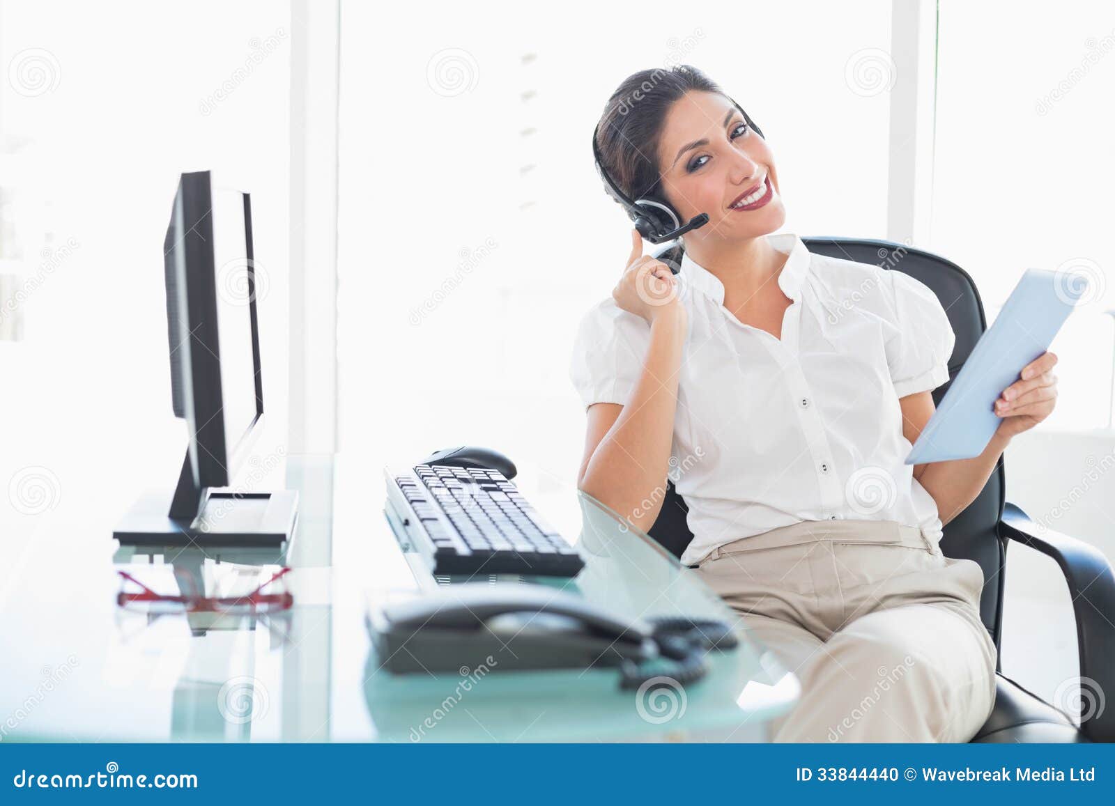 Cheerful Call Centre Agent Using Her Digital Tablet on a Call Stock ...
