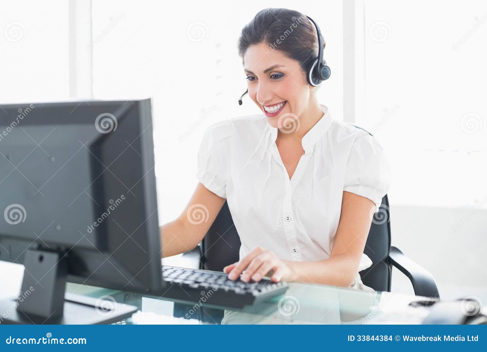 Cheerful Call Centre Agent Working at Her Desk on a Call Stock Photo ...