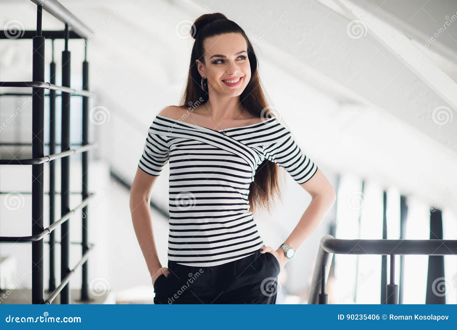 Cheerful Casual Woman Standing with Her Arms in Pockets and Smiling ... Cheerful Casual Woman Standing with Her Arms in Pockets and Smiling ...