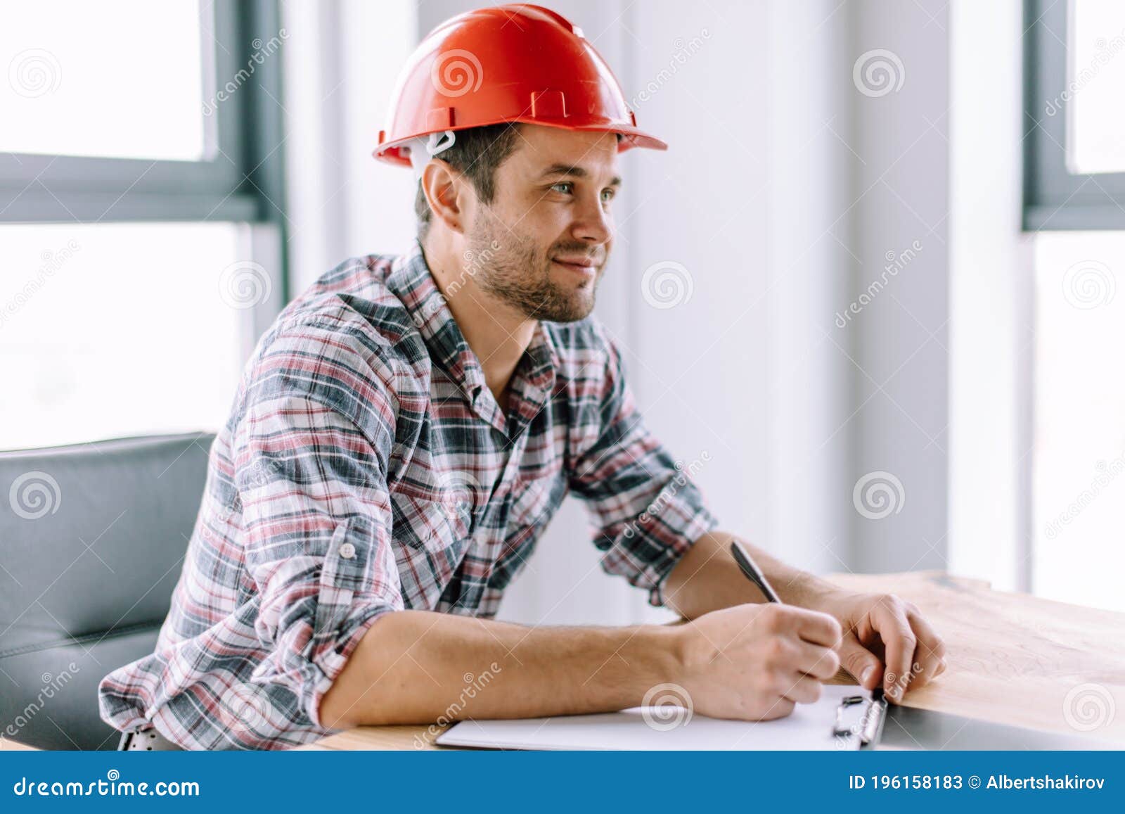Cheerful Constructor Worker Sitting with a Pen and Paper Stock Image ...