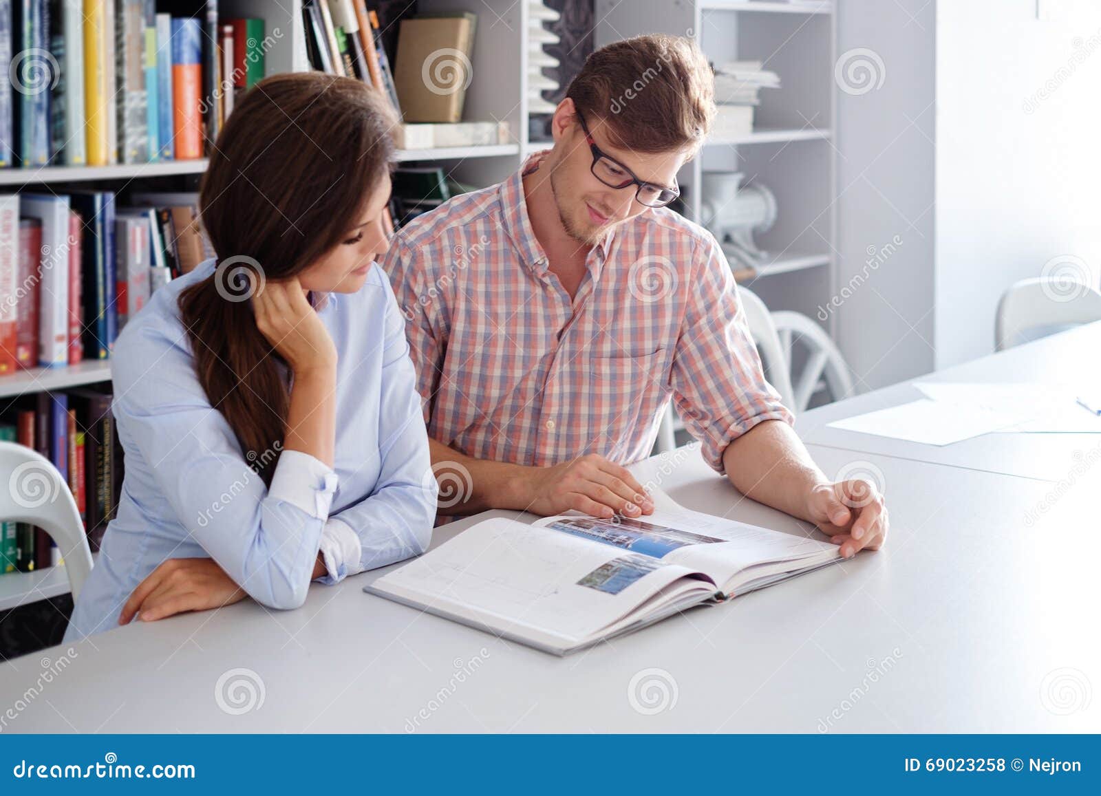 Cheerful Couple of Engineers Having Fun Reading a Book in a Architect ...