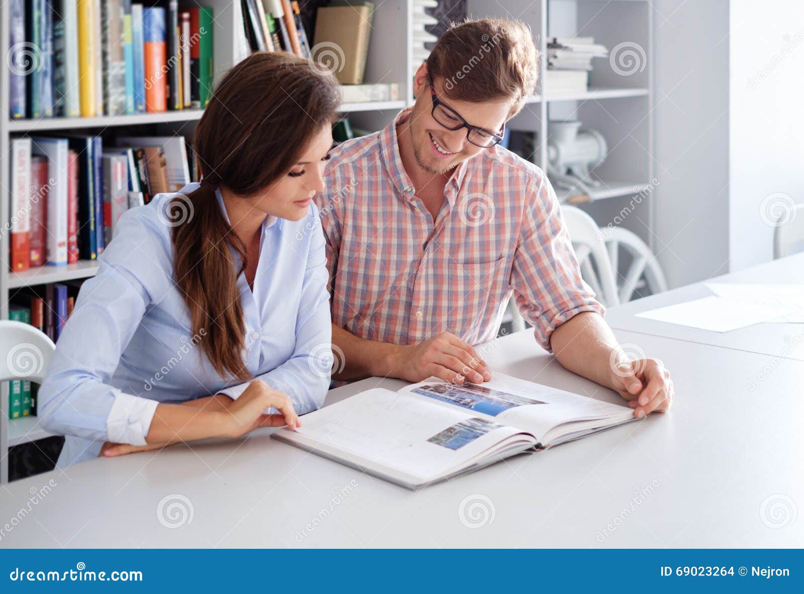 Cheerful Couple of Engineers Having Fun Reading a Book in a Architect ...