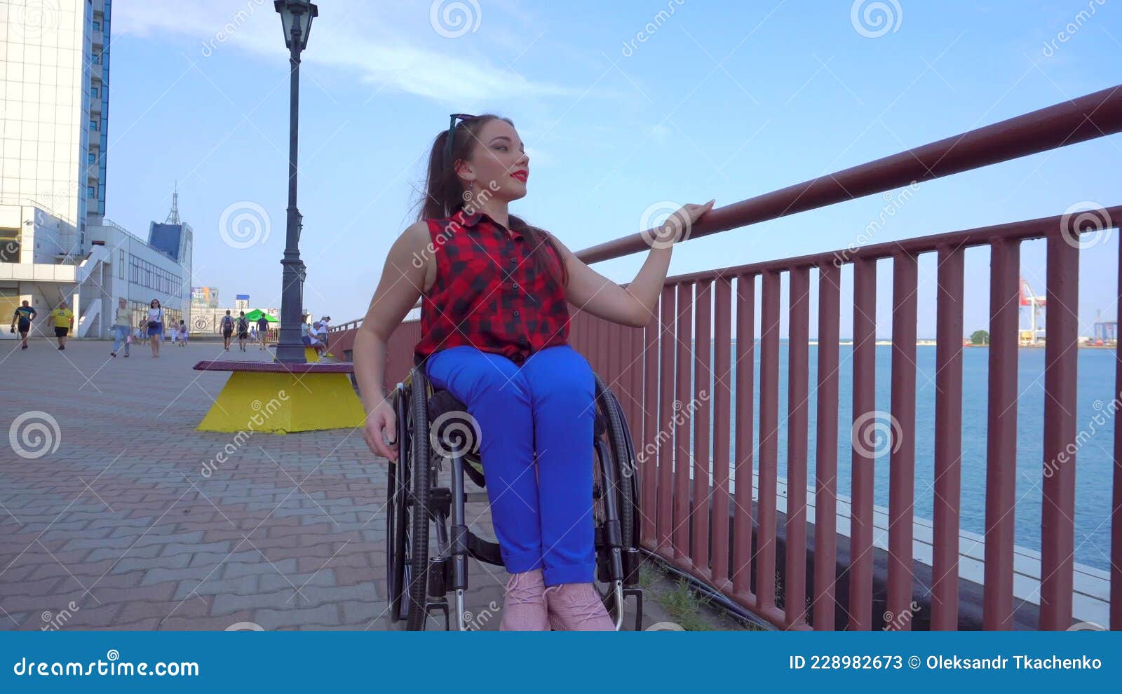 Cheerful Cute Girl In Wheelchair In Casual Outfit Is Walking By The