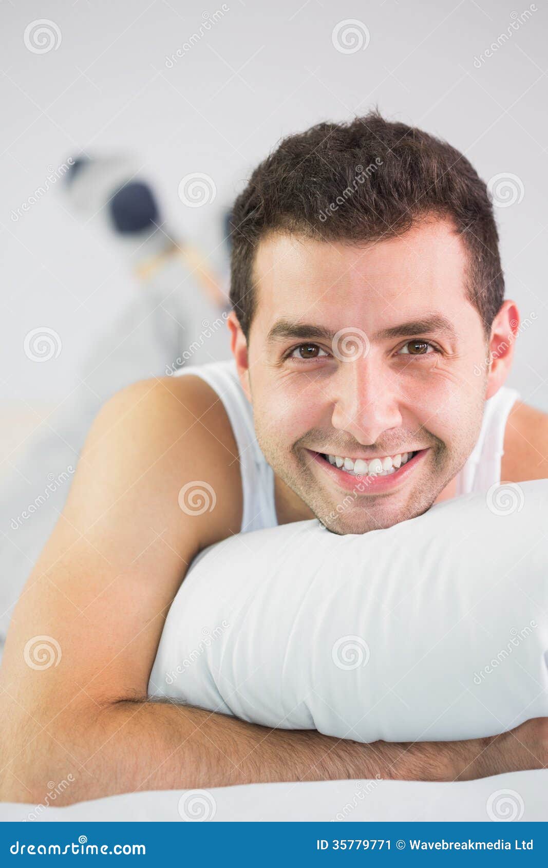 Cheerful Handsome Man Lying In Bed Looking At Camera Stock Image
