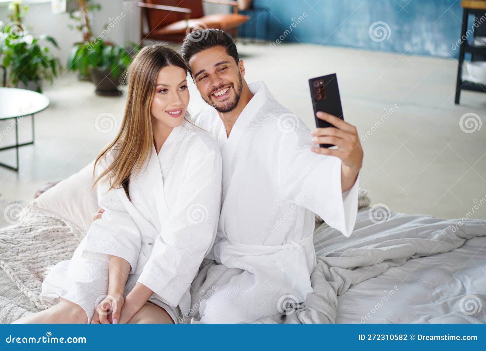 Cheerful And Happy Couple Taking Selfie In Bedroom Having Fun Together