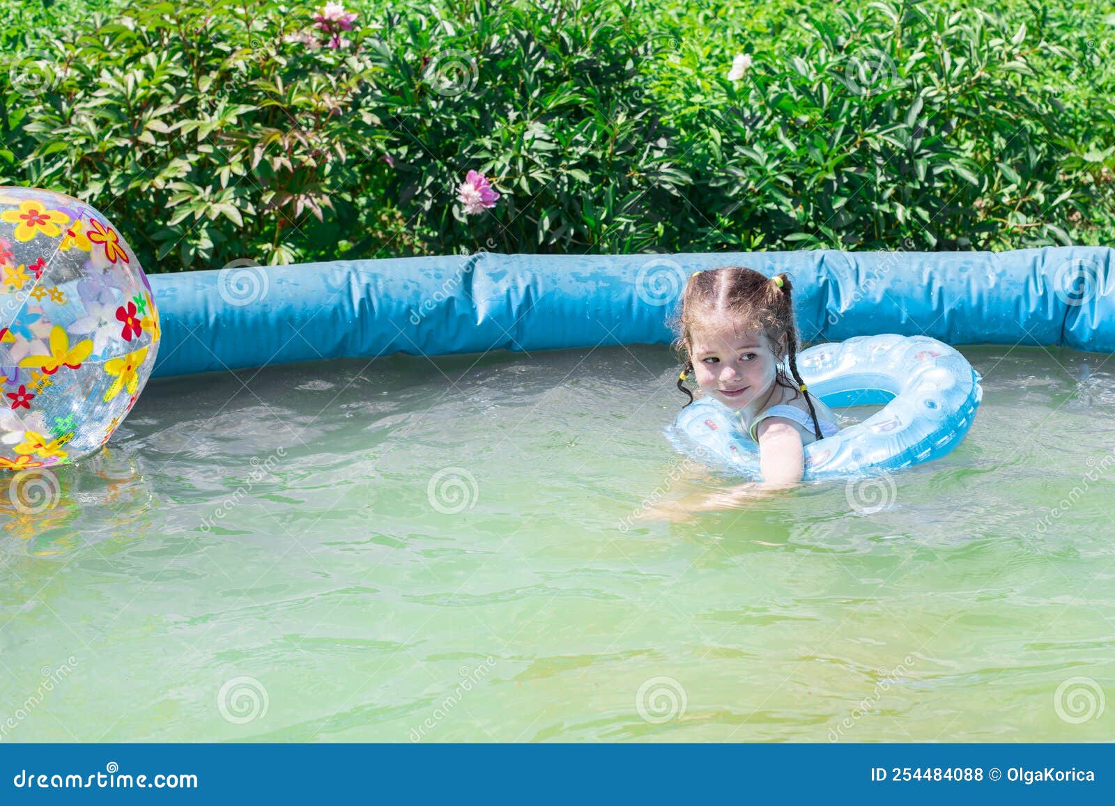 Cheerful Happy Girl Floating On An Inflatable Circle In The Pool