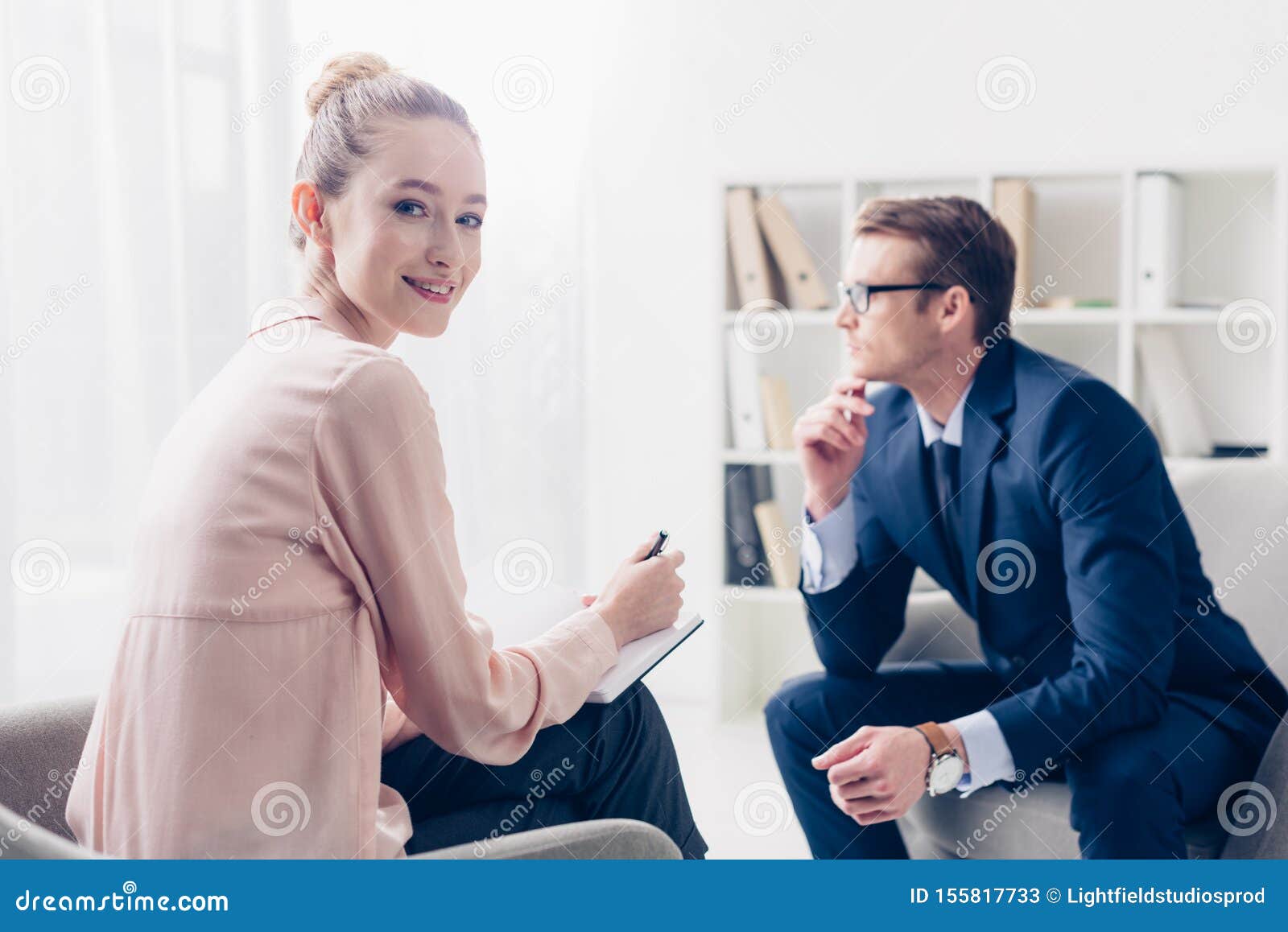 Cheerful Journalist Taking Notes during Interview with Businessman in ...