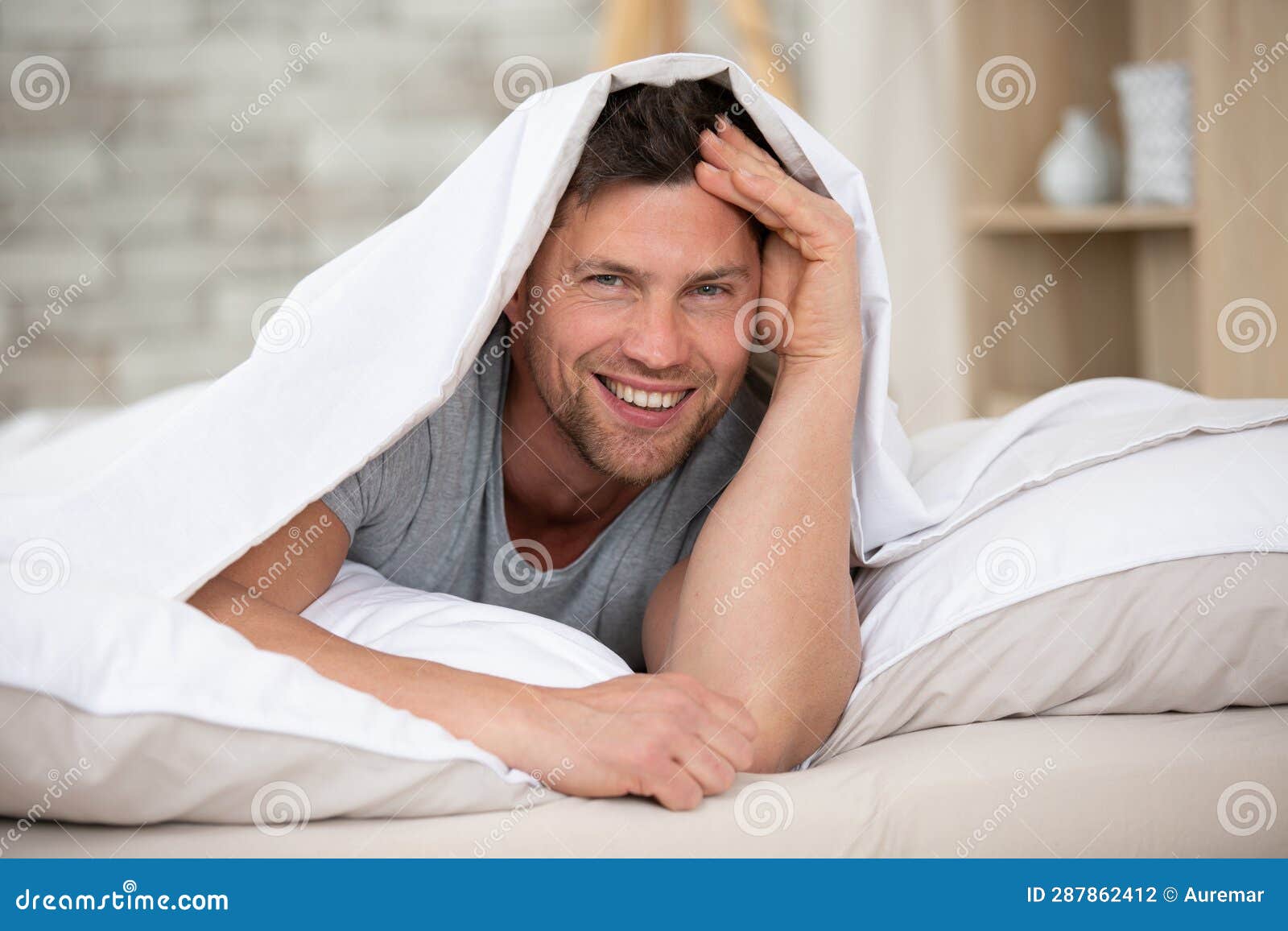 Cheerful man awake in bed stock photo. Image of hand - 287862412