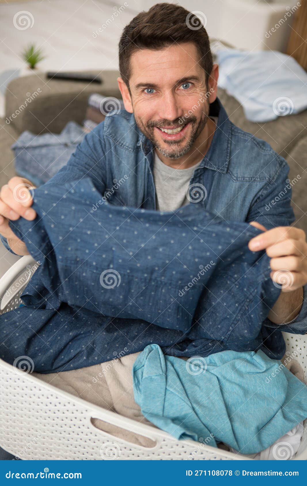 Cheerful Man Holding Garment from Laundry Basket Stock Photo - Image of ...