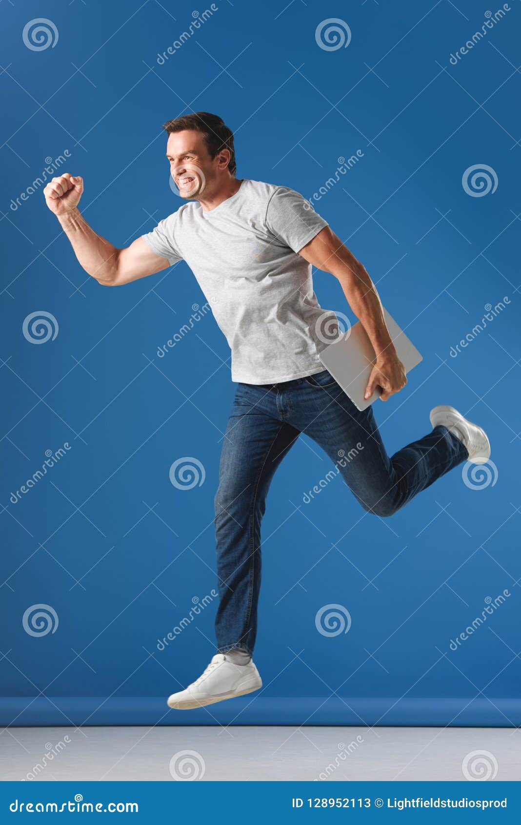 Cheerful Man Holding Laptop and Jumping Stock Image - Image of young ...
