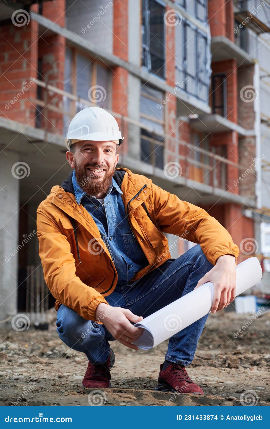 Man Builder Crouching Down Outdoors at Construction Site. Stock Photo ...