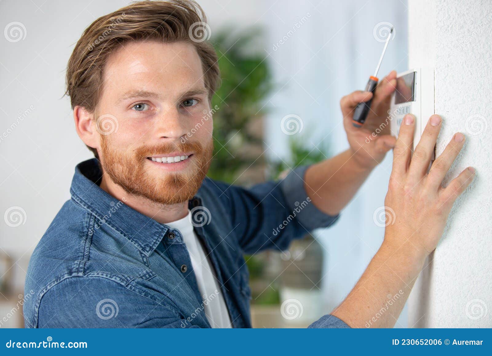Cheerful Man with Screwdriver Installing Security System on Wall Stock ...