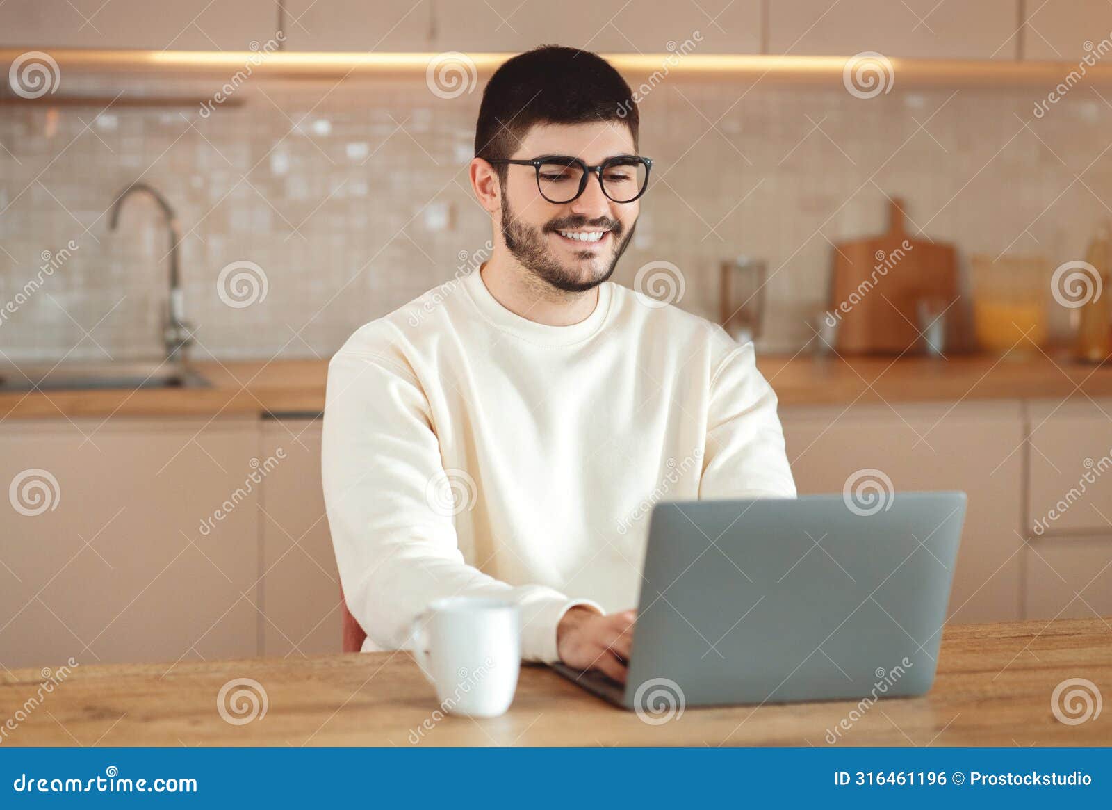 Cheerful Man Sitting at Table Using Laptop Computer Stock Photo - Image ...