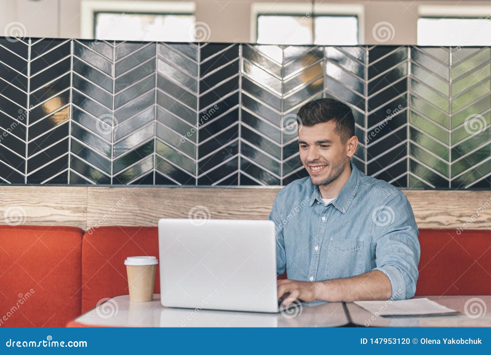 Cheerful Man Smiling and Working on His Laptop in Cafe Stock Photo ...