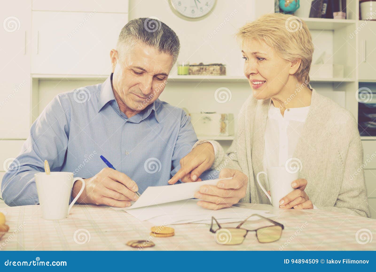 Cheerful Mature Couple at Table Attentively Study Documents Stock Image ...