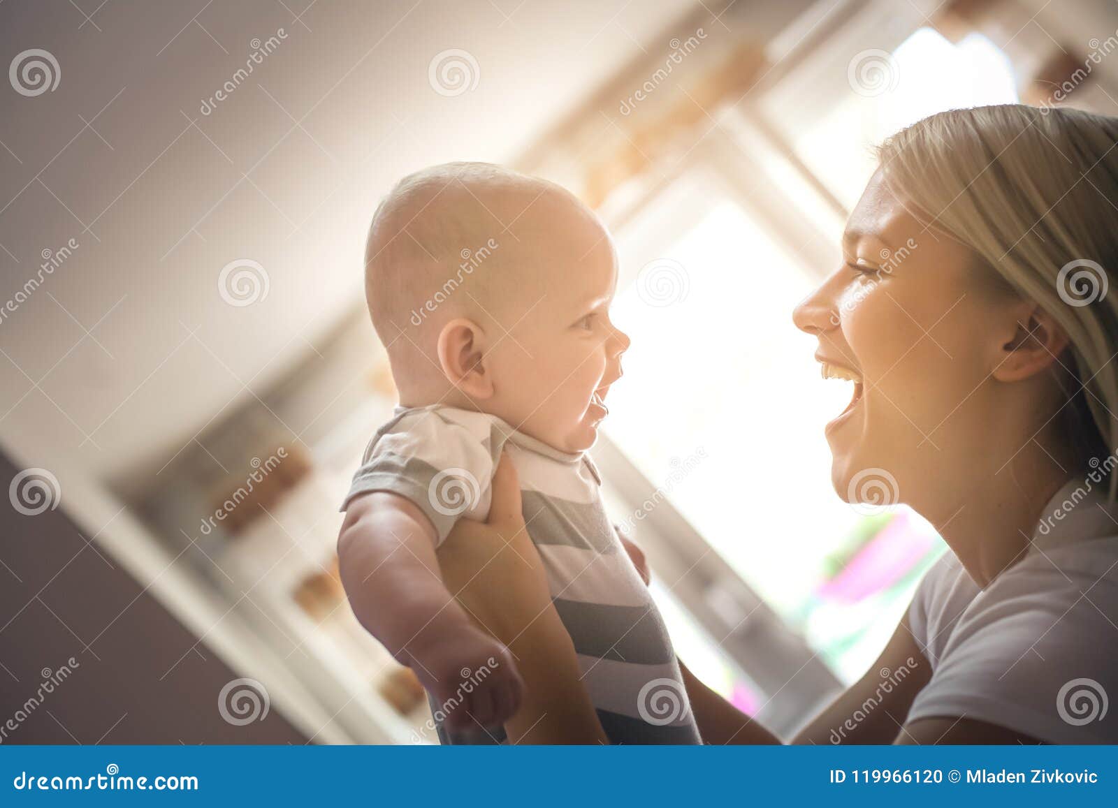 Cheerful Mother Holding Her Little Baby Boy in Hand High. Stock Photo ... Cheerful Mother Holding Her Little Baby Boy in Hand High. Stock Photo ...