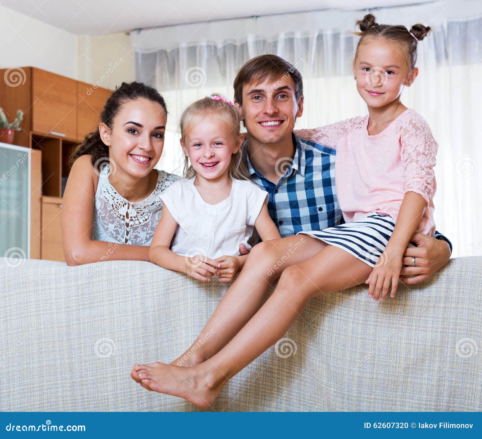 Cheerful Parents with Two Daughters Stock Photo - Image of middle, room ...