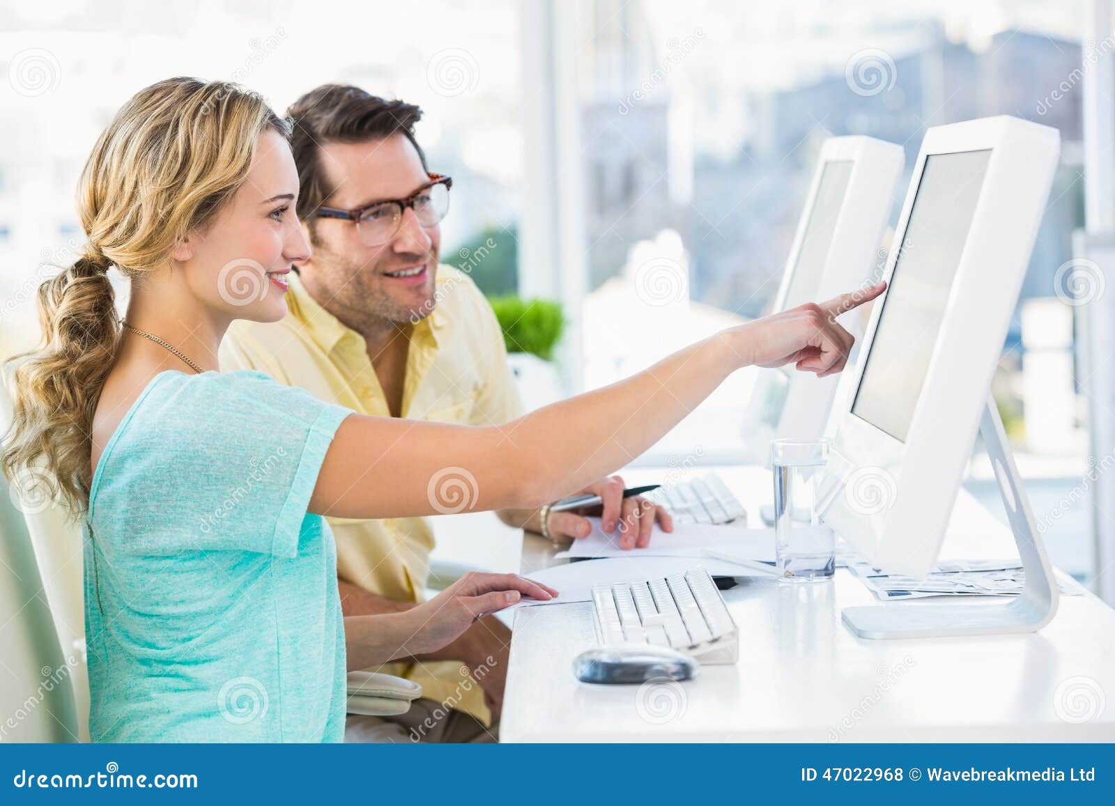 Cheerful Photo Editor Pointing at a Computer Stock Photo - Image of ...