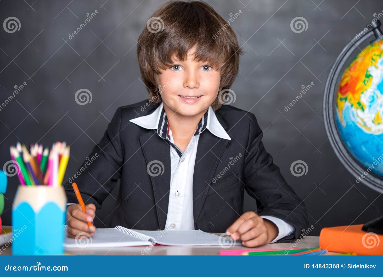 Cheerful School Boy Writing in Notebook Stock Photo - Image of globe ...