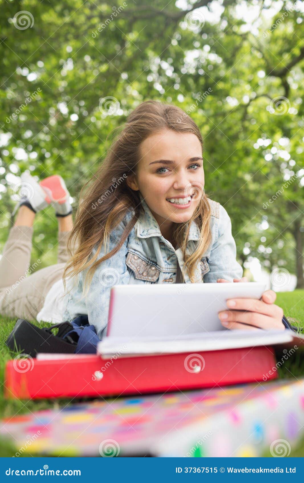 Cheerful Student Lying on the Grass Studying with Her Tablet Pc Stock ...