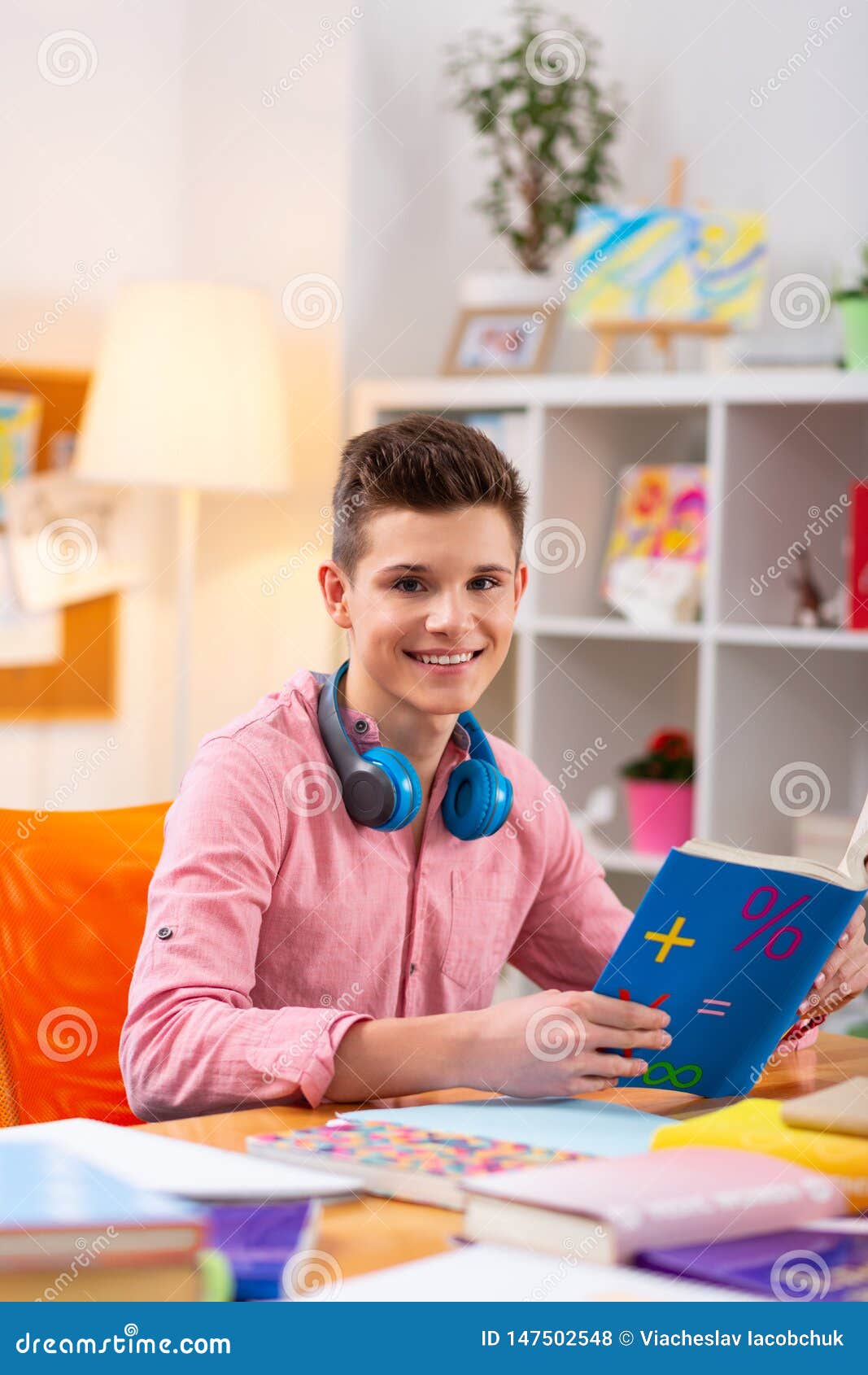 Cheerful Student Reading Math Book while Sitting at the Table Stock ...