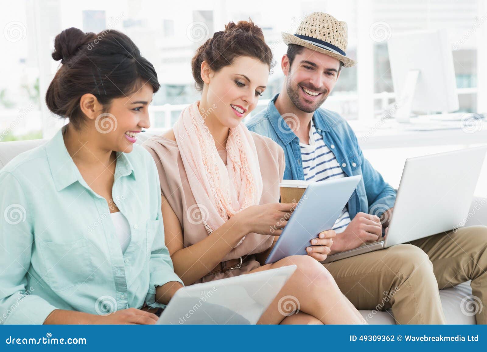 Cheerful Teamwork Using Laptop and Tablet on Couch Stock Photo - Image ...